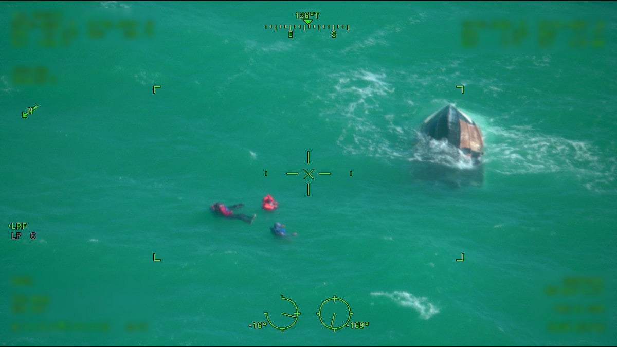 US Coast Guard and Navy rescue four people from capsized boat