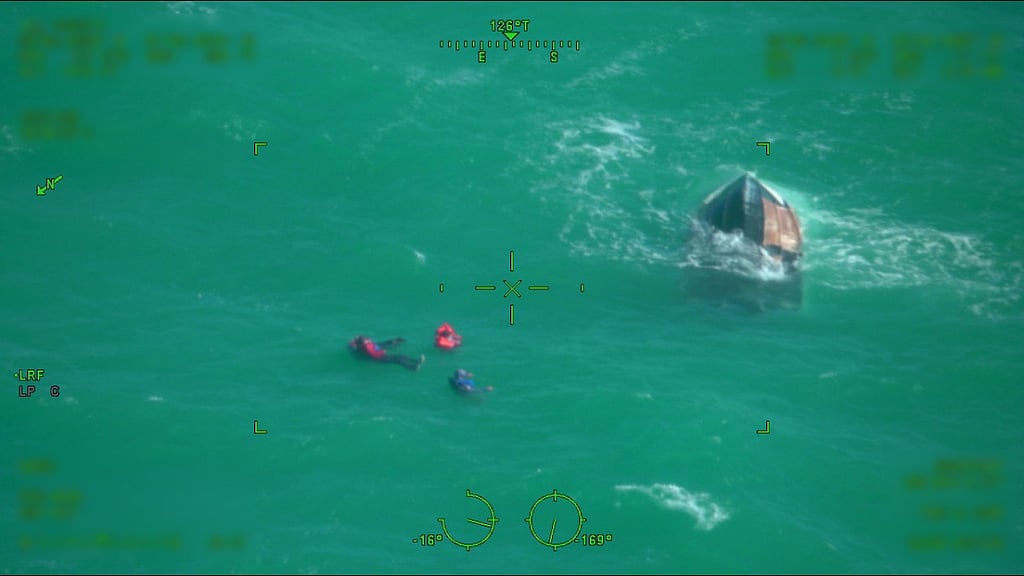US Coast Guard and Navy rescue four people from capsized boat