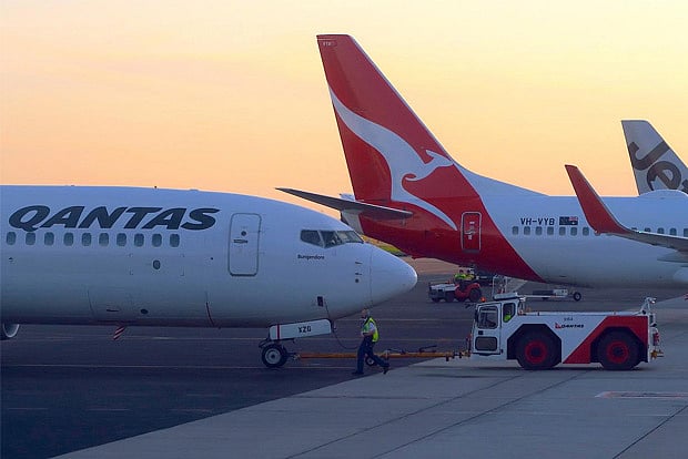 Passengers evacuate Qantas plane via emergency slides at Sydney airport
