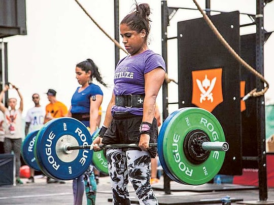 Emirati women cross a barrier with CrossFit