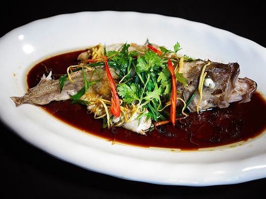 Chinese-style steamed fish in soy sauce and spring onion