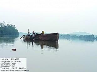 Locals spot men in boat extracting river sand with suction pump at Macazana