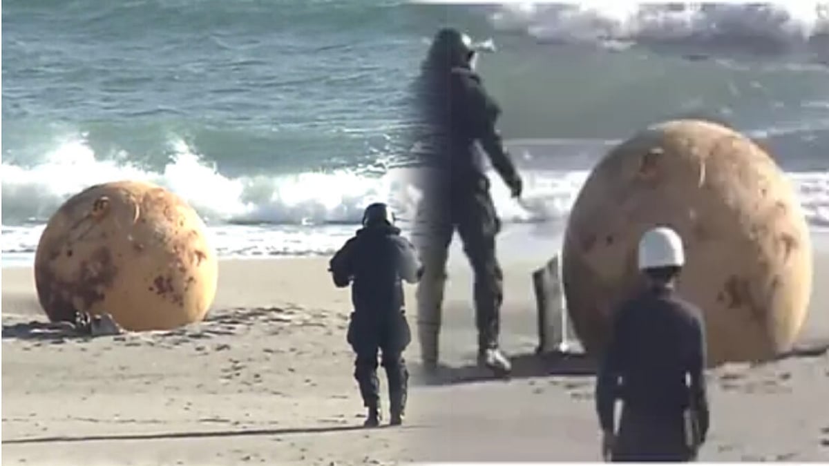 A big iron ball lying on the beach.. People are panicking as it is a bomb