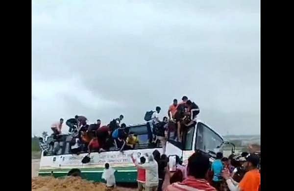 Passengers climb onto roof of bus stuck in flooding in Shimla