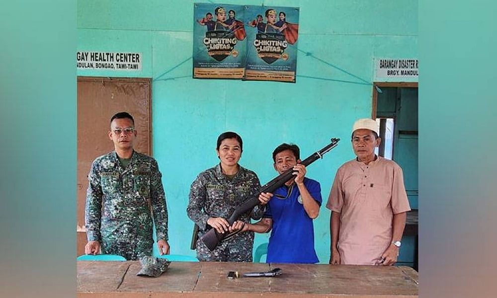 Village chief hands over loose firearms to military